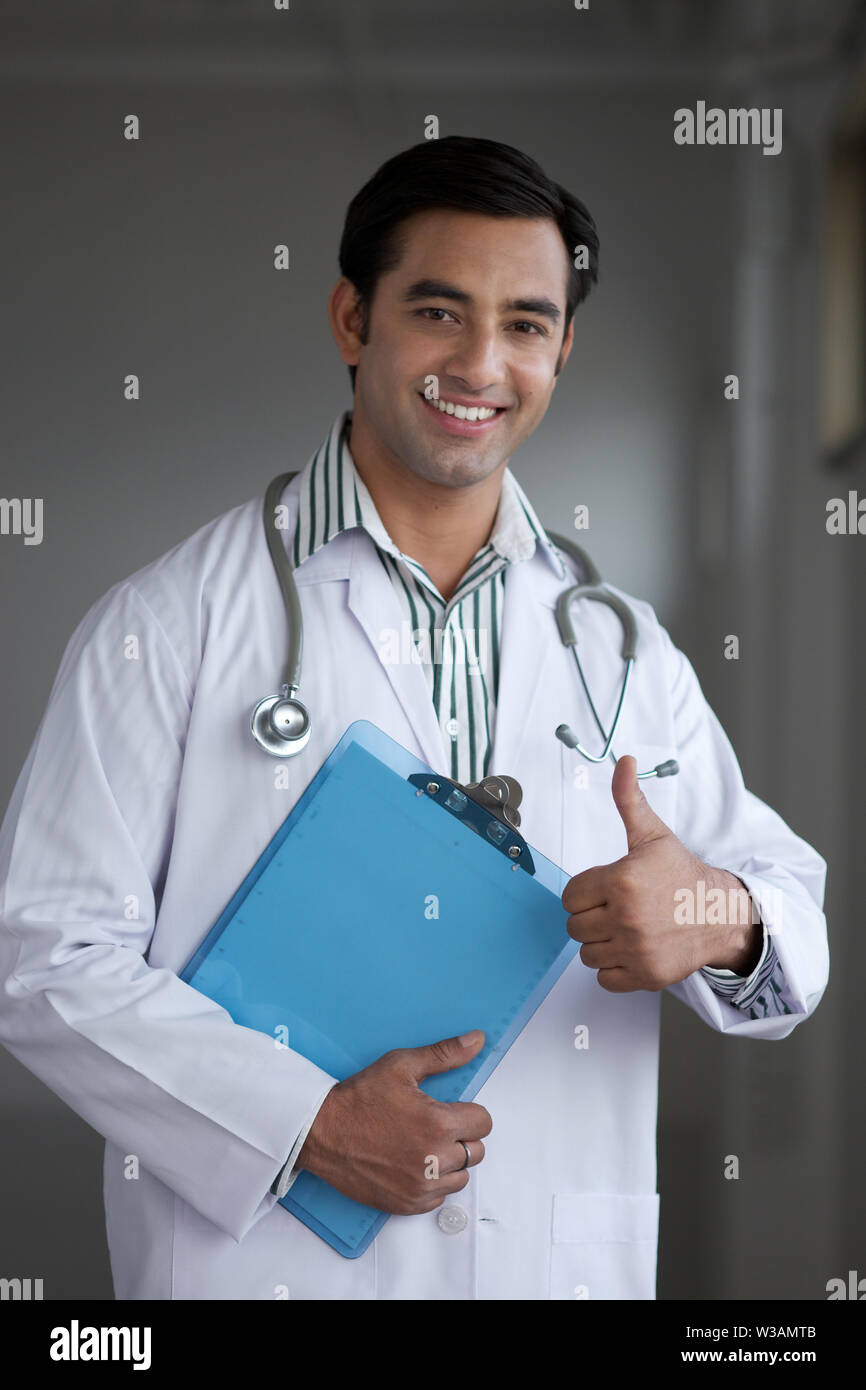 Portrait of a male doctor showing thumbs up sign Stock Photo - Alamy