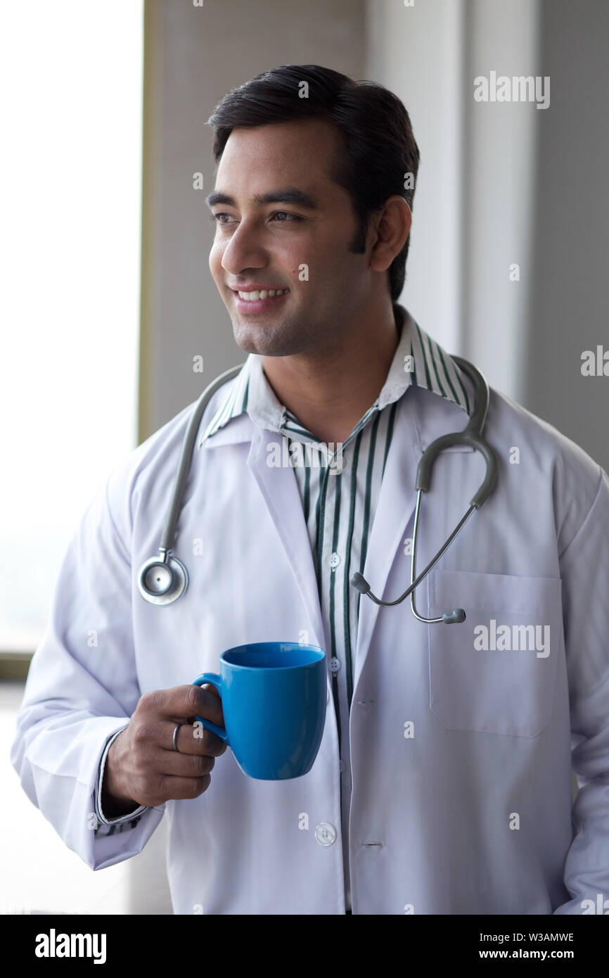 Male doctor having a cup of coffee Stock Photo - Alamy