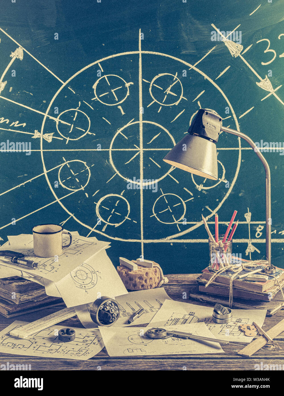 Mechanical engineer desk at the school on green chalkboard background ...