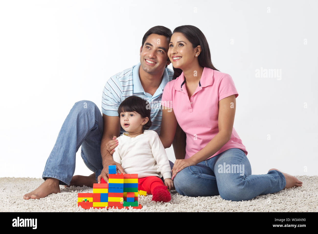Family sitting on rug Stock Photo - Alamy