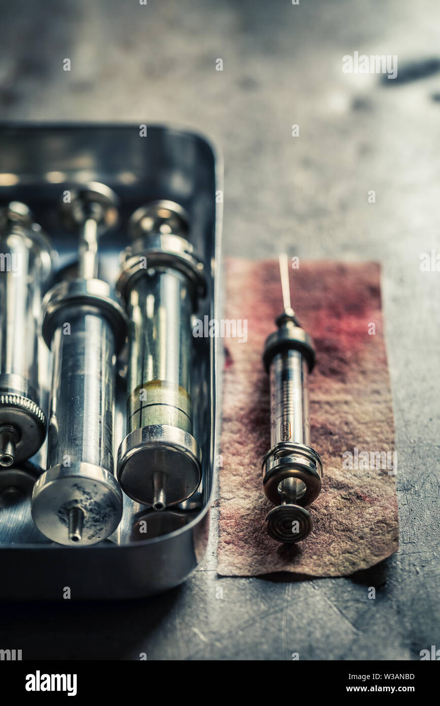 Classic syringes with a needle prepared on red bandage Stock Photo - Alamy