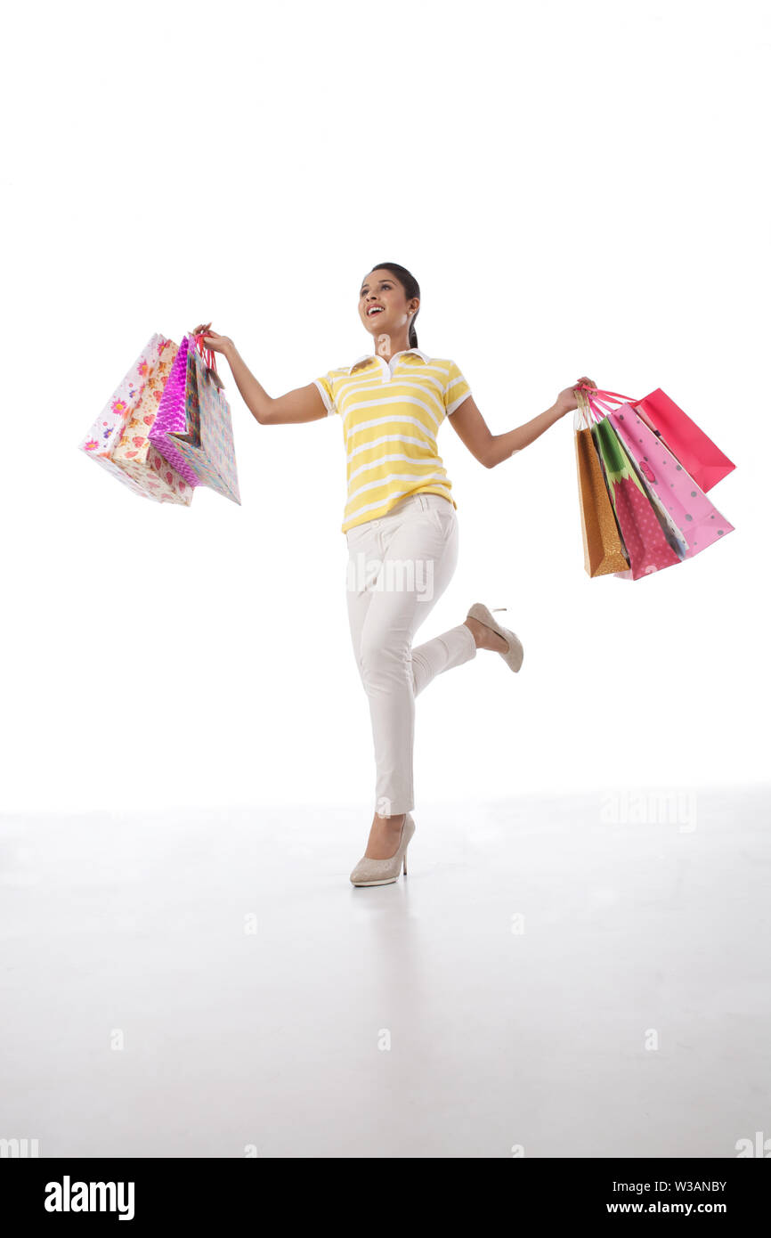 Woman running with shopping bags and smiling Stock Photo - Alamy