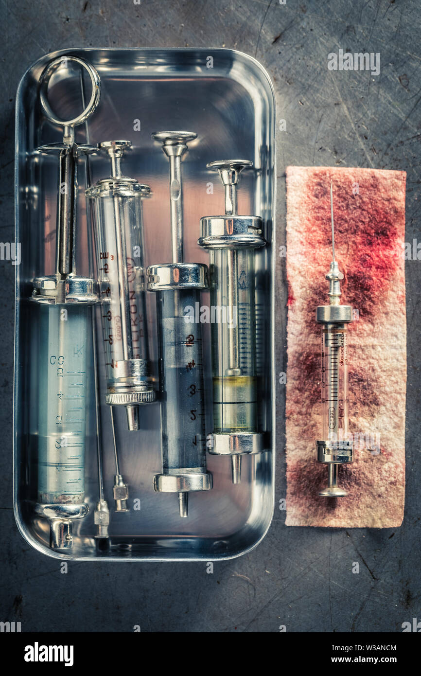 Antique syringes with a needle prepared on red bandage Stock Photo - Alamy