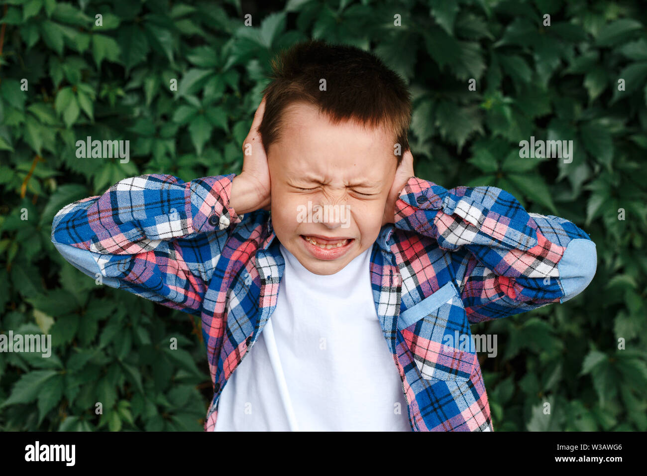 Annoyed stressed boy cover ears feel hurt ear ache pain Stock Photo - Alamy