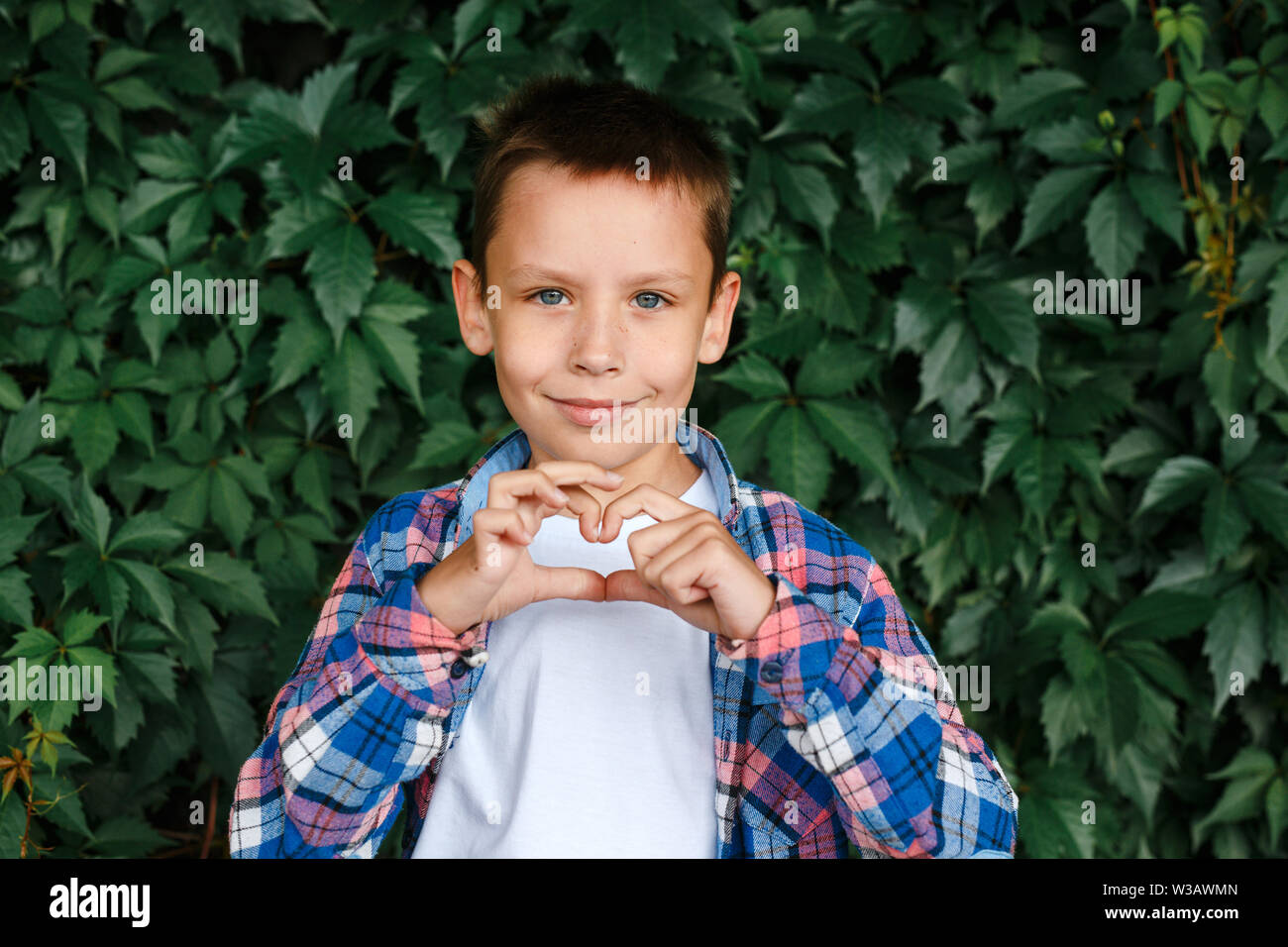 Happy boy making a heart shape with his hands Stock Photo - Alamy