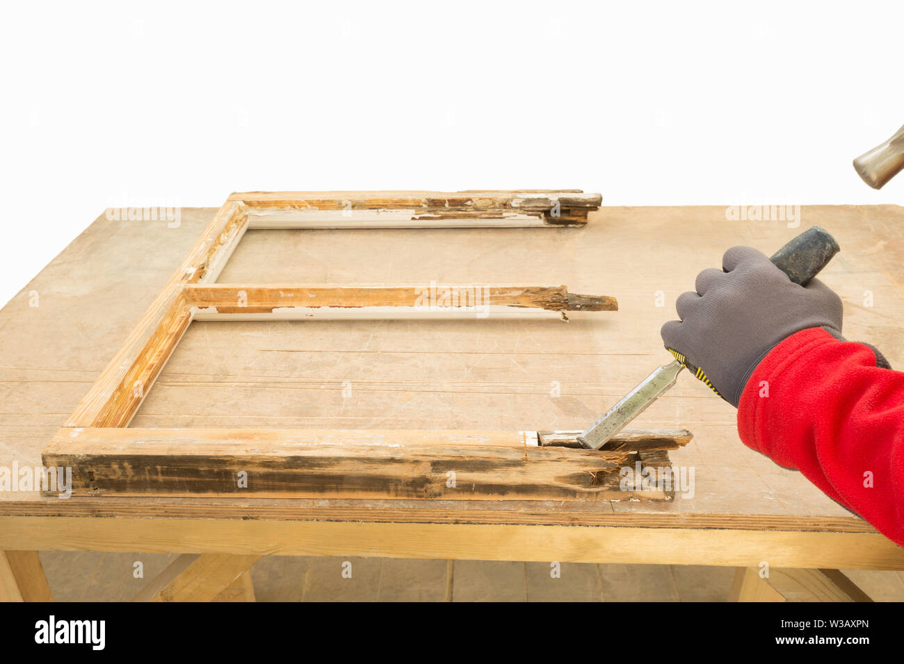 Restoration of a window frame. Carpenter using a chisel while repairing ...
