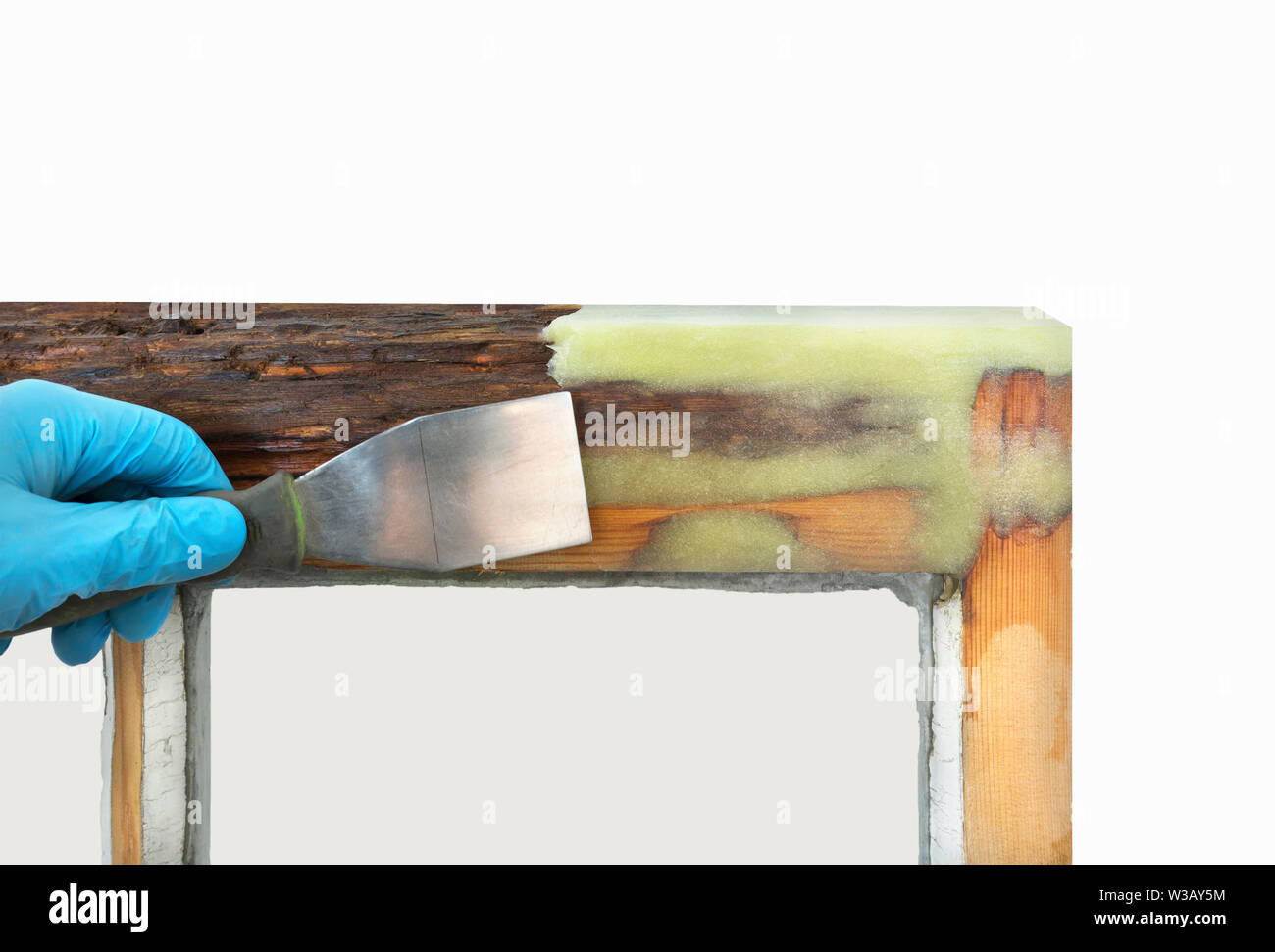 Close up of a person applying resin with spatula to old sash window ...