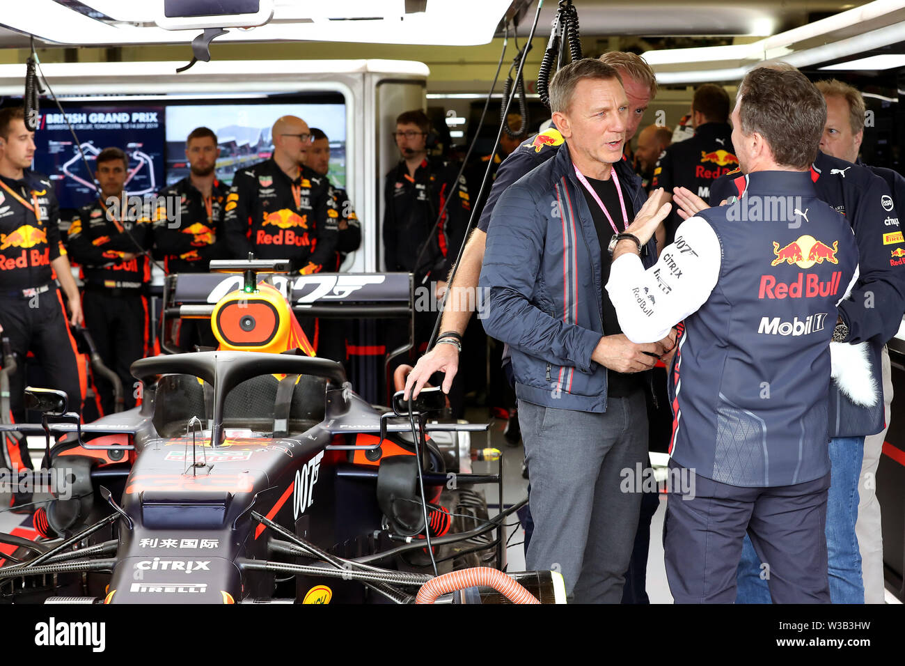 Daniel Craig (left) speaks with Christian Horner in the Red Bull garage ...