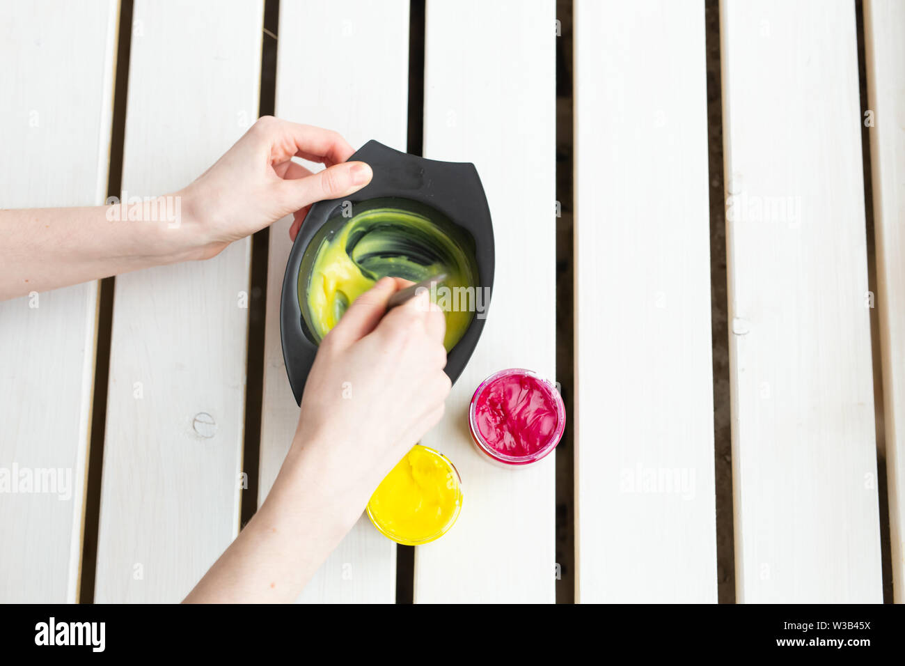 Color and hairdresser concept - female hairdresser in process of mixing ...