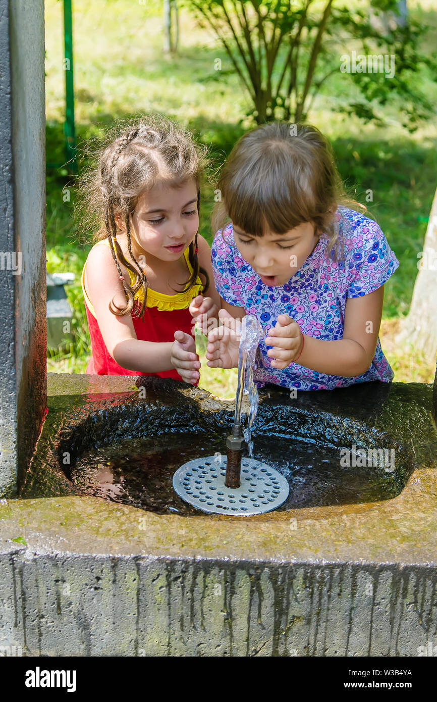 children drink water from a spring in Borjomi, Georgia. Selective focus ...