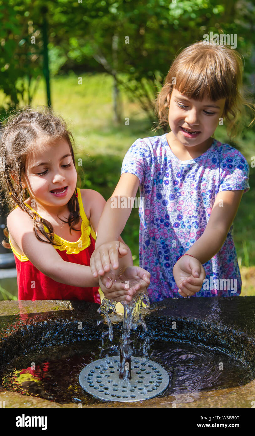 children drink water from a spring in Borjomi, Georgia. Selective focus ...