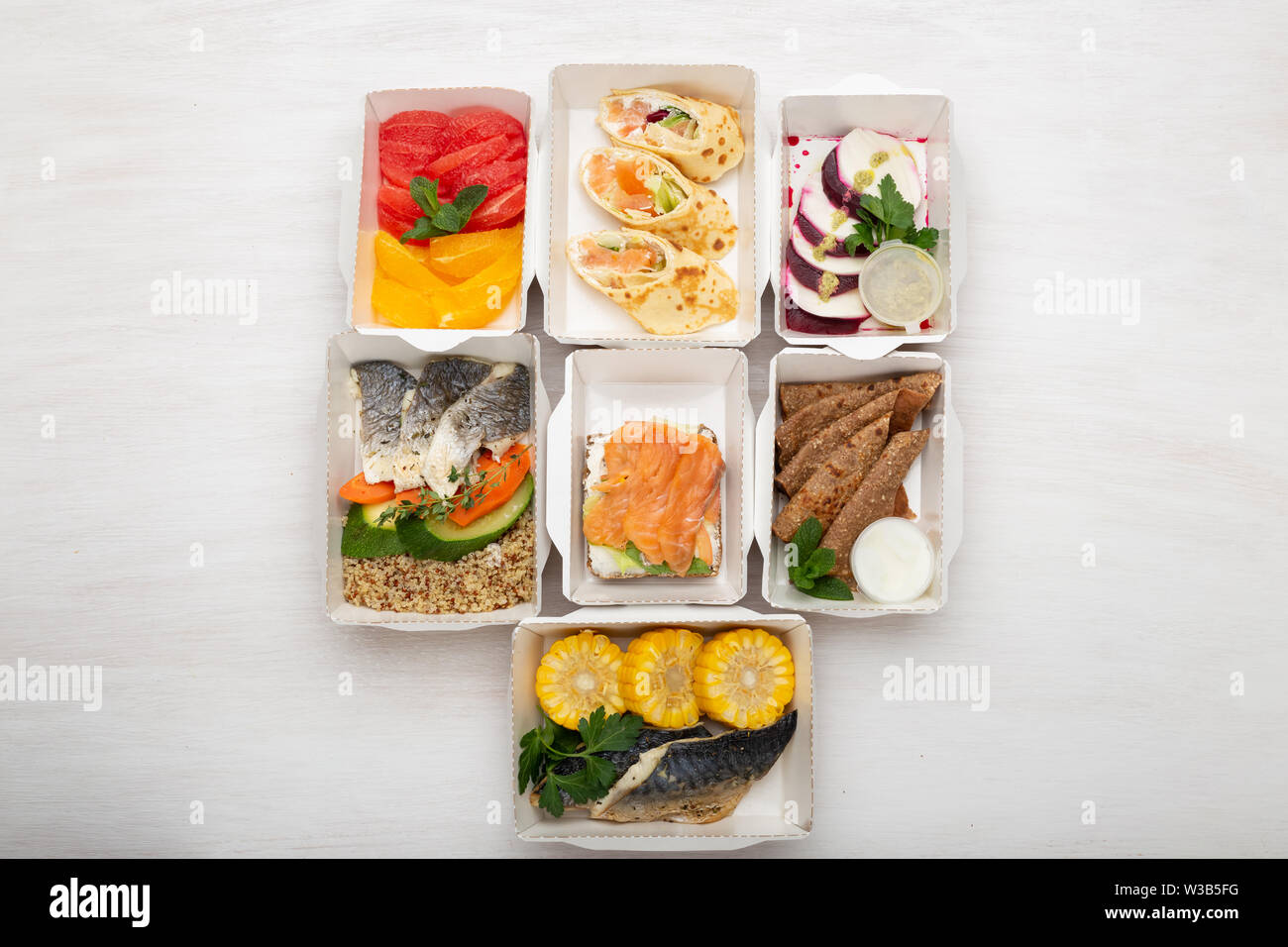 Set of healthy meals for the day in lunch boxes stands on a white table ...
