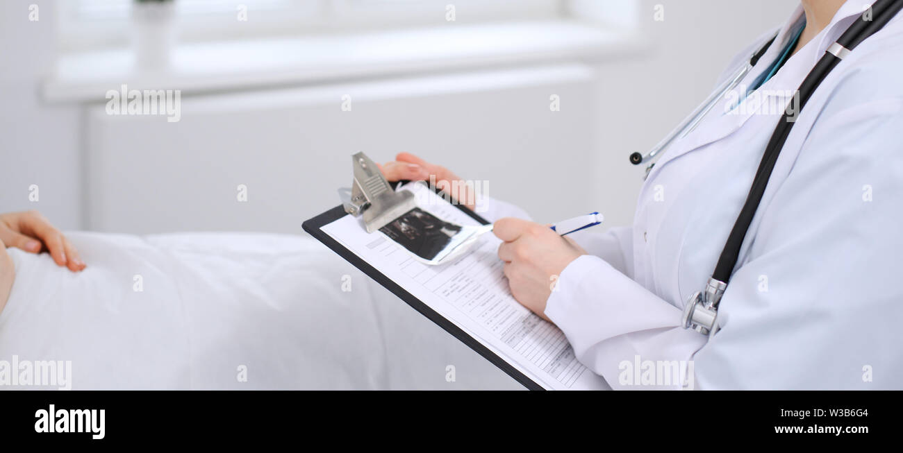 Female doctor holding application form while consulting patient Stock ...