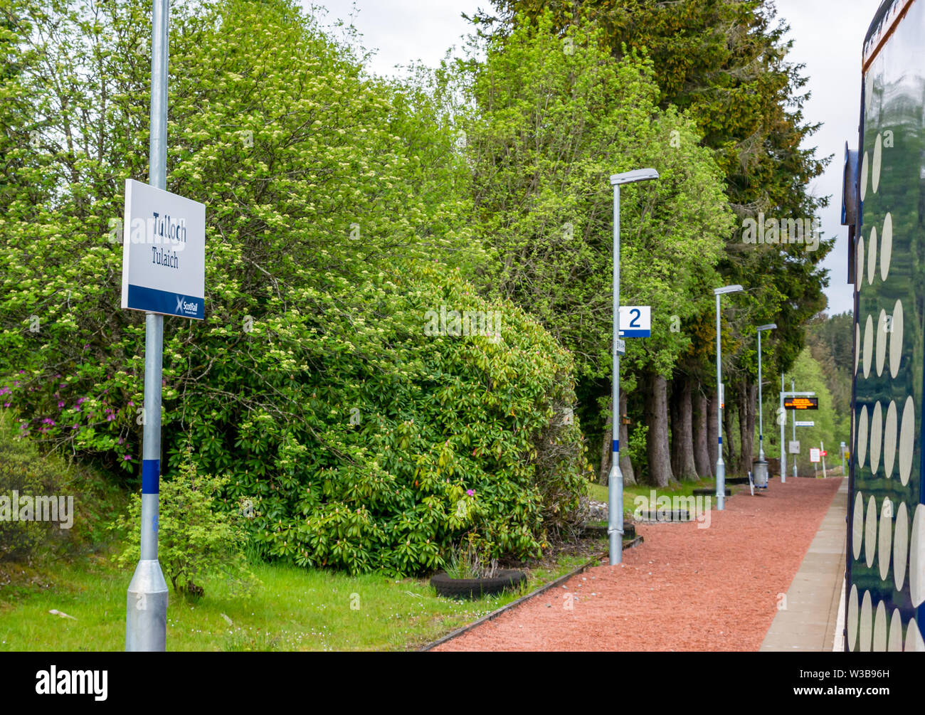 Tulloch rural train station platform with name sign and ScotRail train ...