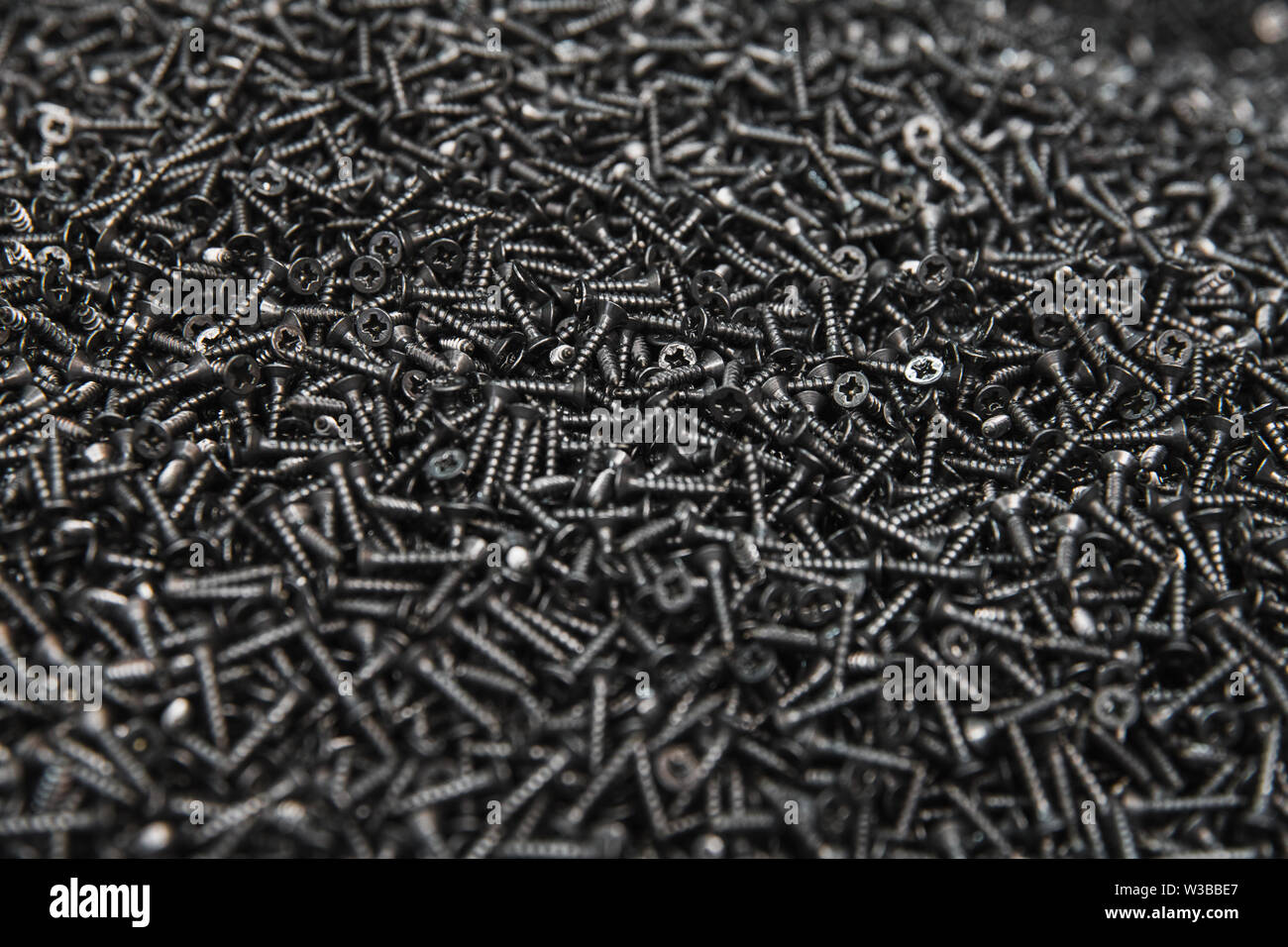 Pile of metal tapping chrome screws abstract background. Iron or metal ...