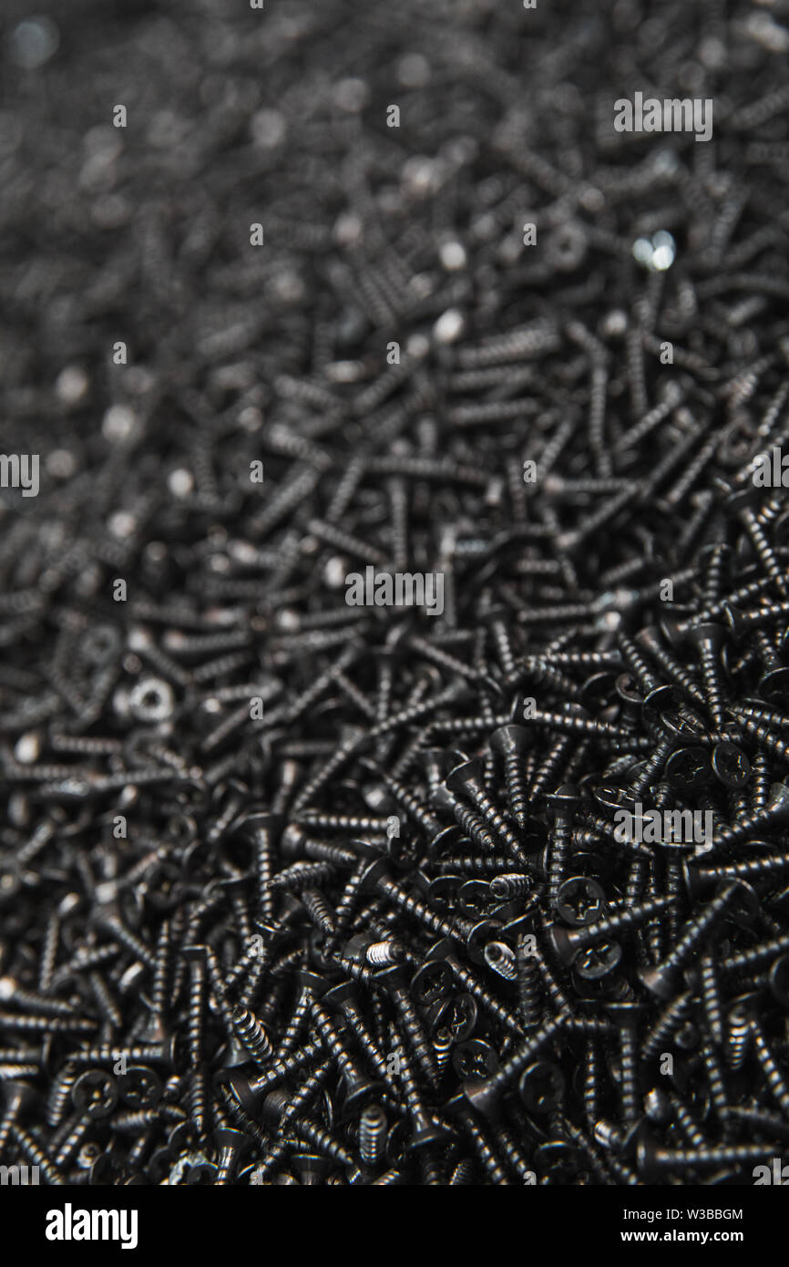 Pile of metal tapping chrome screws abstract background. Iron or metal ...