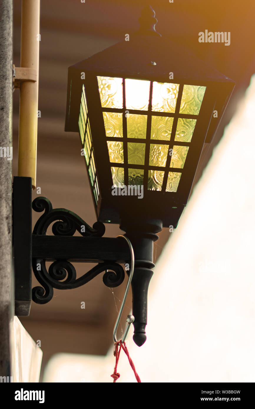 yellow luminous lantern hang on the facade of the building. street ...