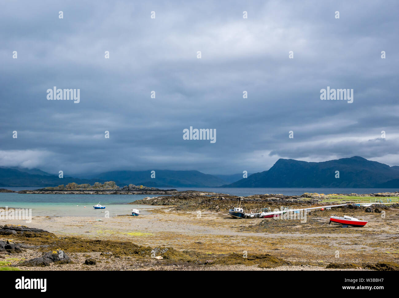 View across Sound of Sleat with moody sky and boats in harbour ...