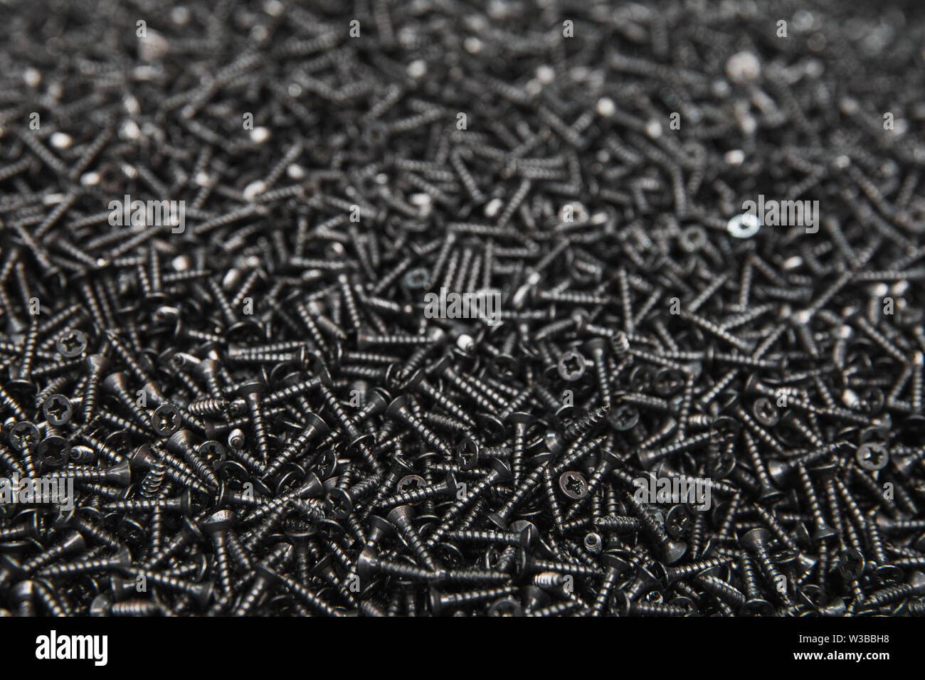Pile of metal tapping chrome screws abstract background. Iron or metal ...