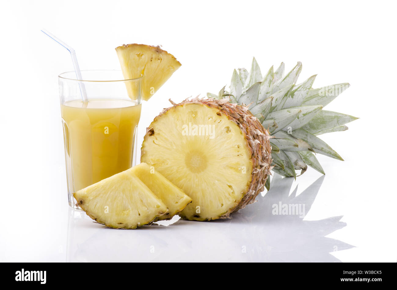 Fresh yellow juice in a glass and pineapple sliced isolated on white ...