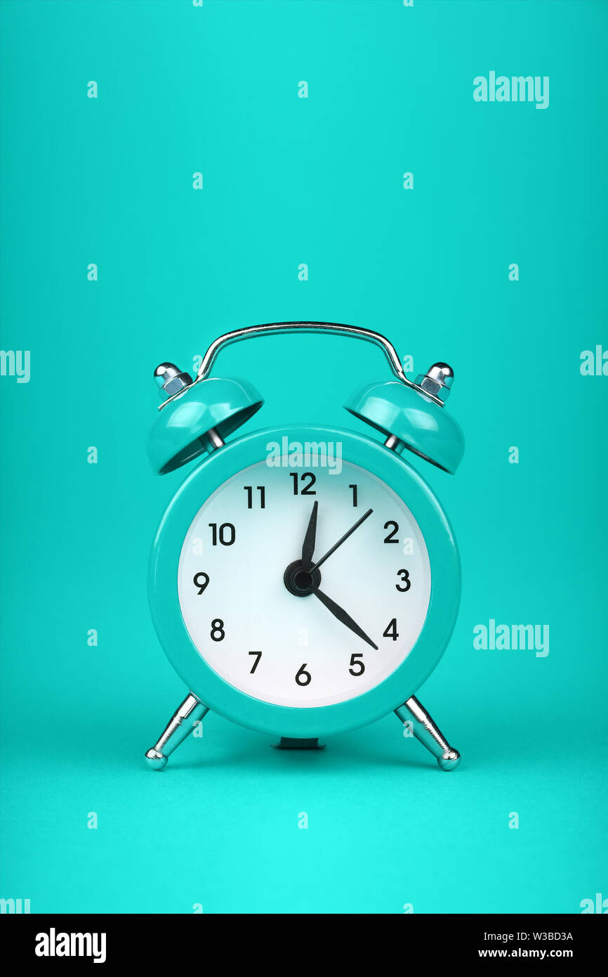 Close up one small teal blue metal twin bell retro alarm clock over ...