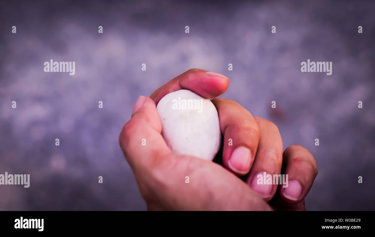 Stone held in hands. Hand hold stone ball in nature. Circular stone ...