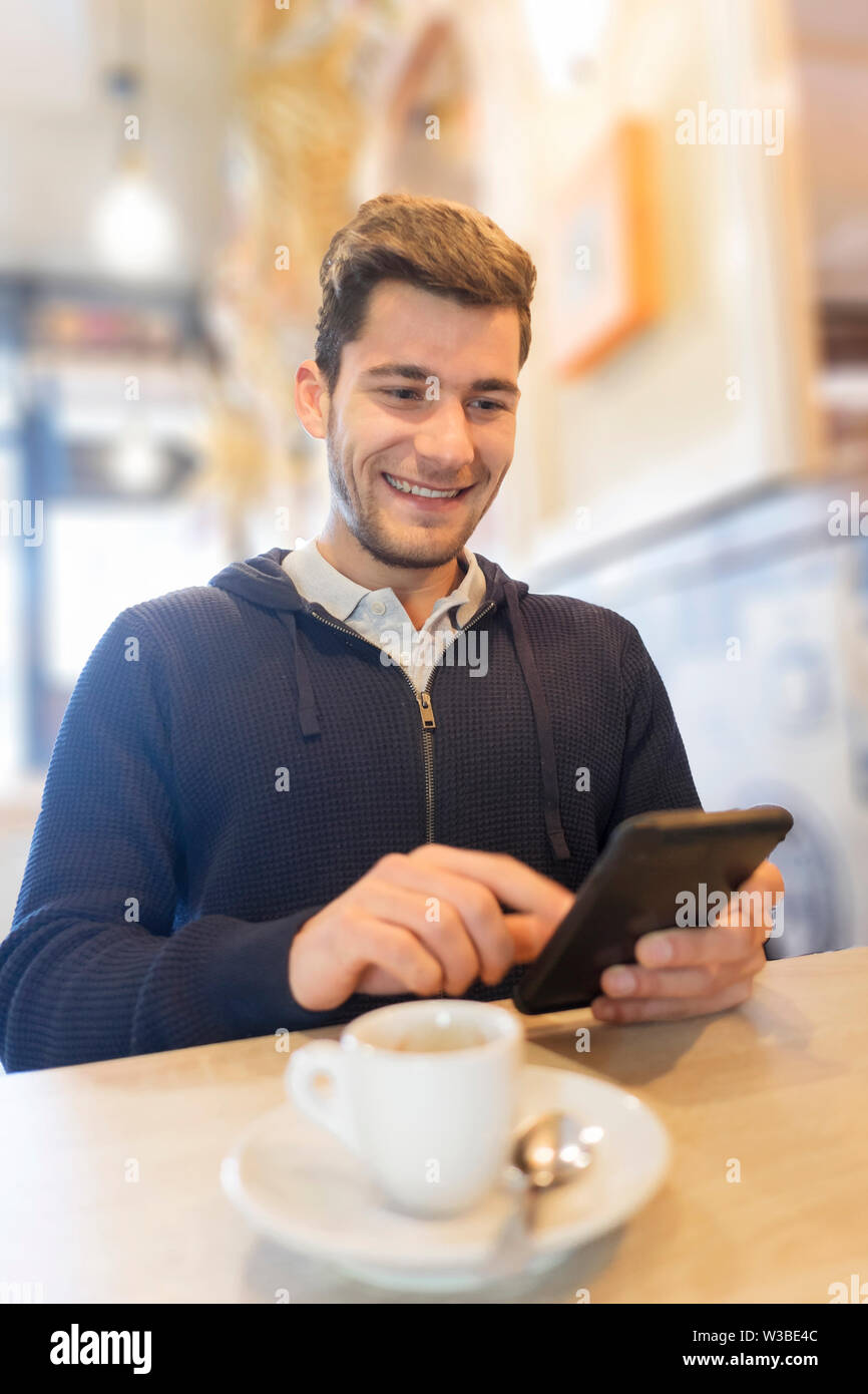 Man using a smartphone on a coffee shop Stock Photo - Alamy