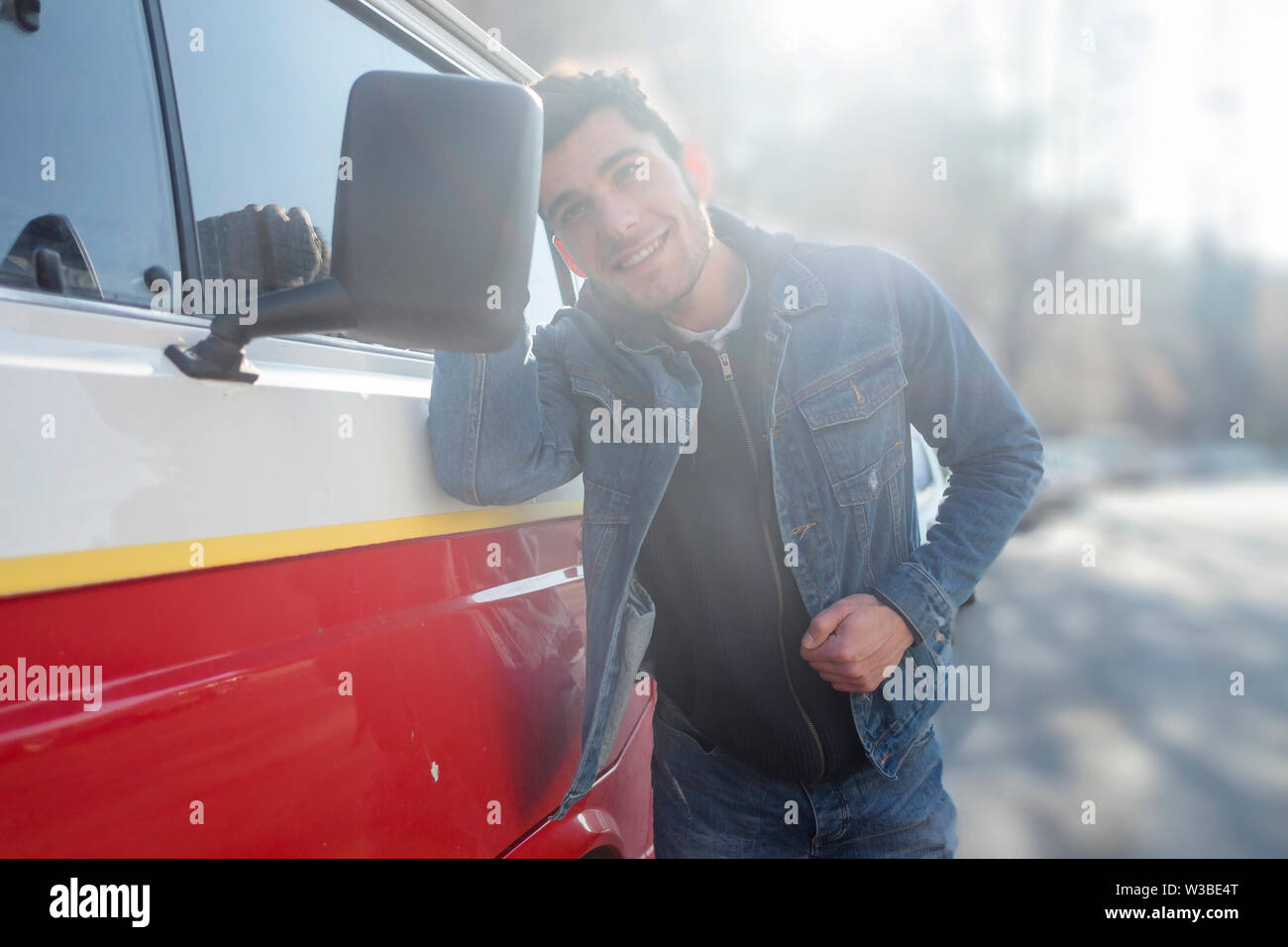 Vain man checking his looks in the mirror of his van Stock Photo - Alamy