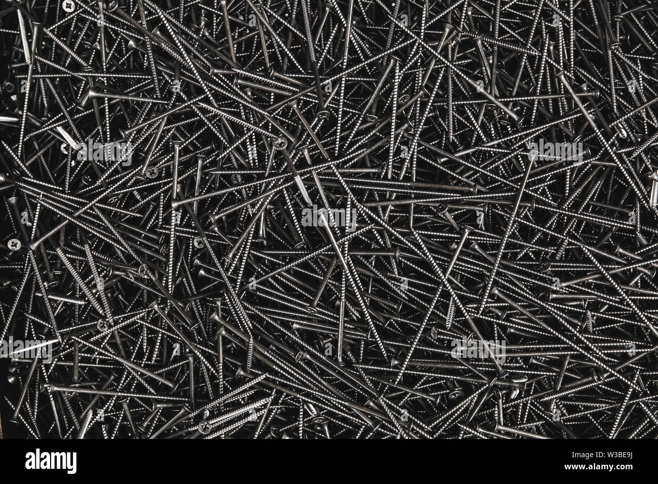 Pile of metal tapping chrome screws abstract background. Iron or metal ...