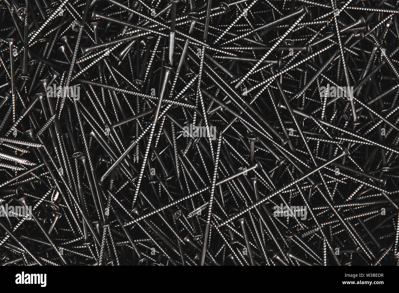 Pile of metal tapping chrome screws abstract background. Iron or metal ...