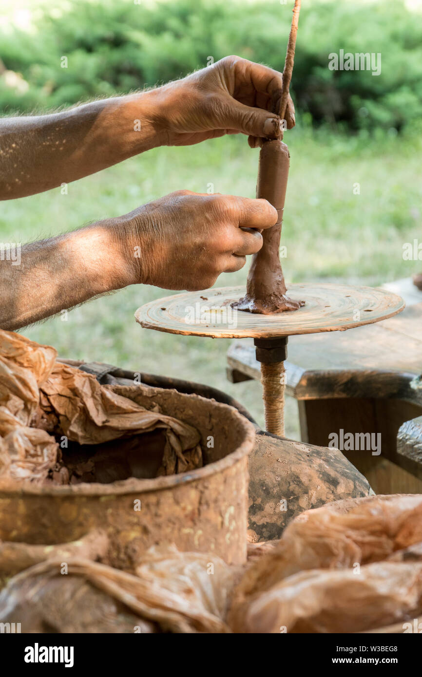 Hands of a artisan creating new clay shape from brown clay. Handicraft ...