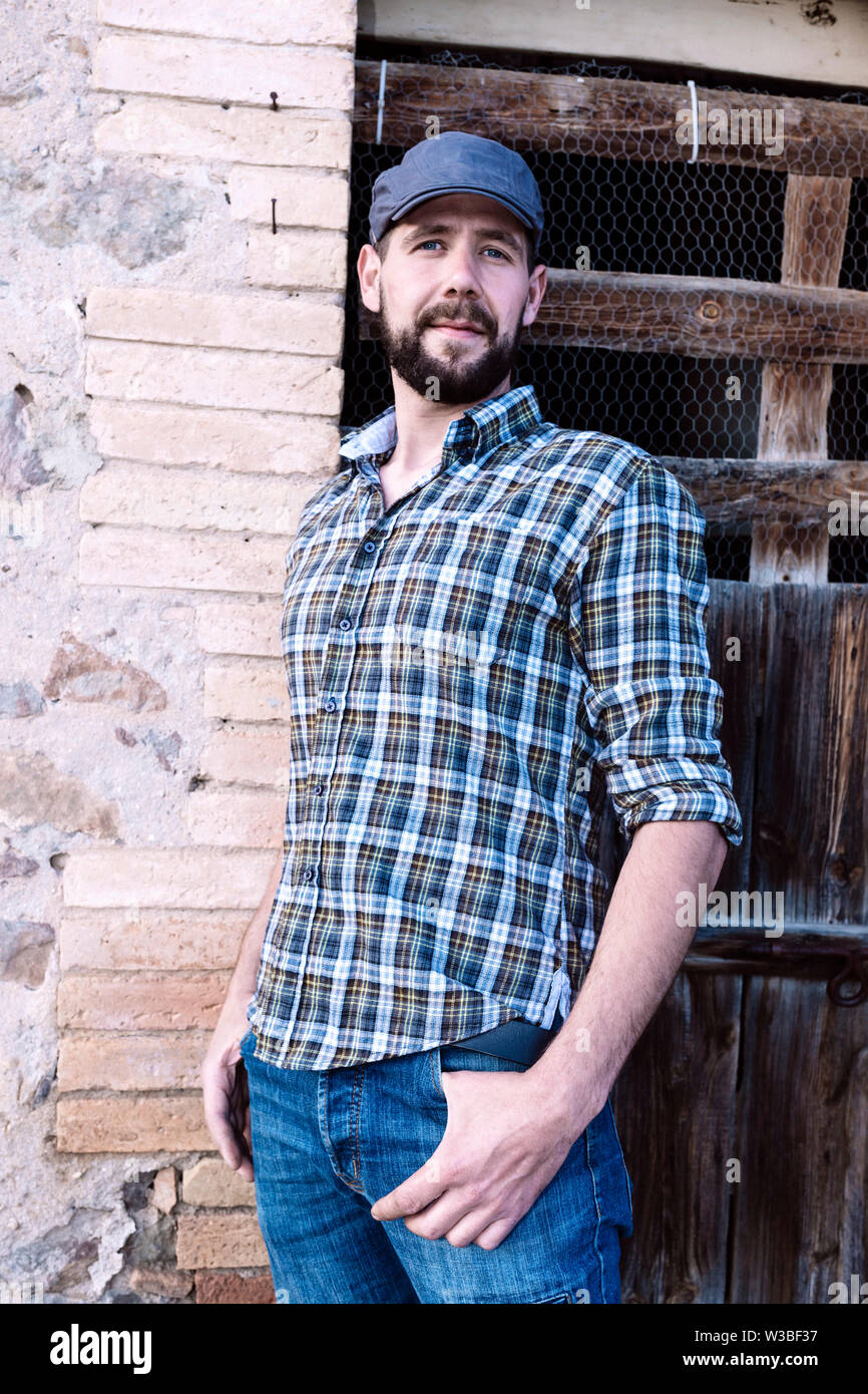 casual young man standing with his back against a brick wall Stock ...