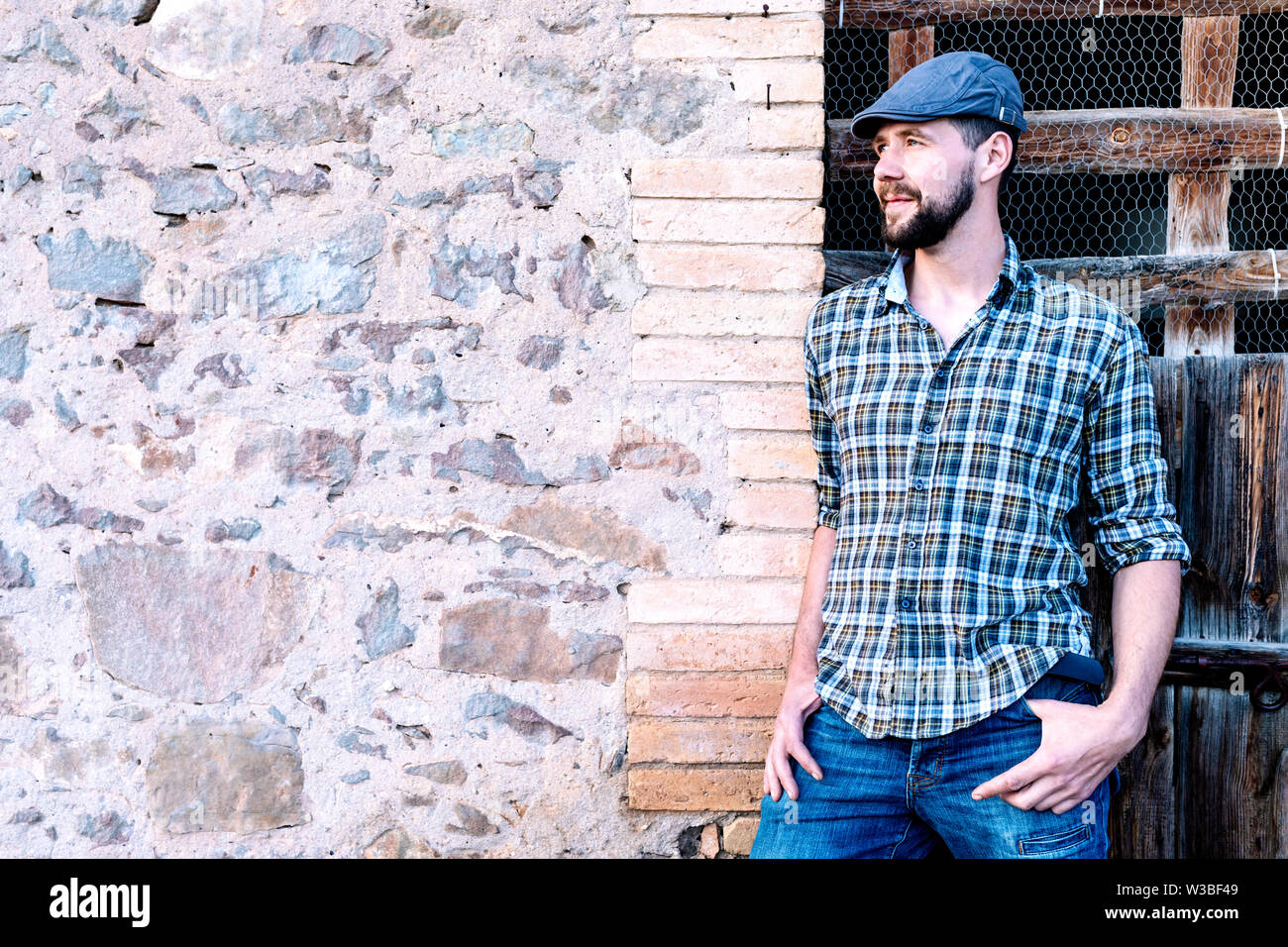 casual young man standing with his back against a brick wall Stock ...