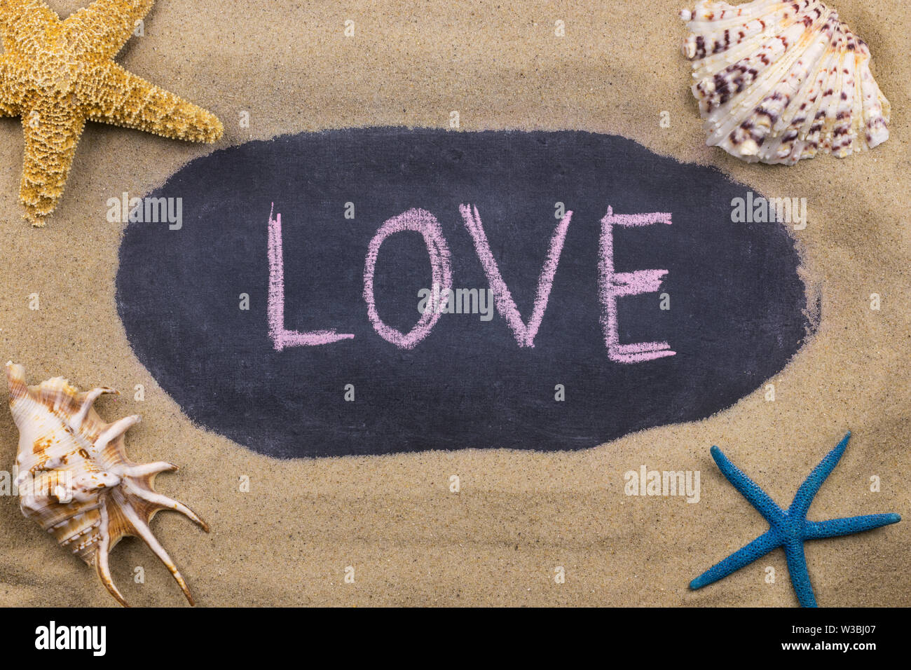 Handwritten chalk inscription LOVE on blackboard, lying among the ...