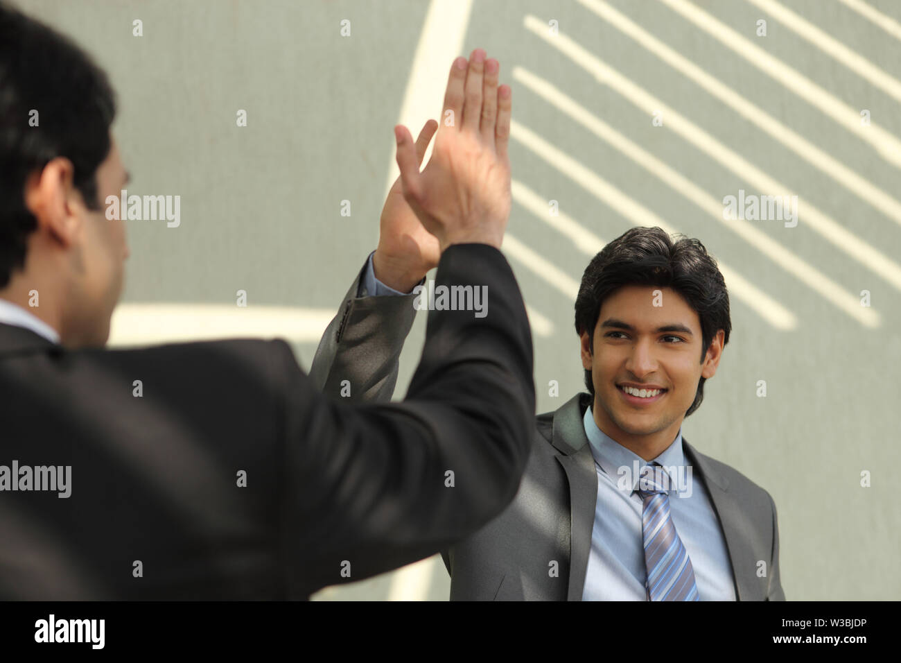 Two business executives giving high-five Stock Photo - Alamy