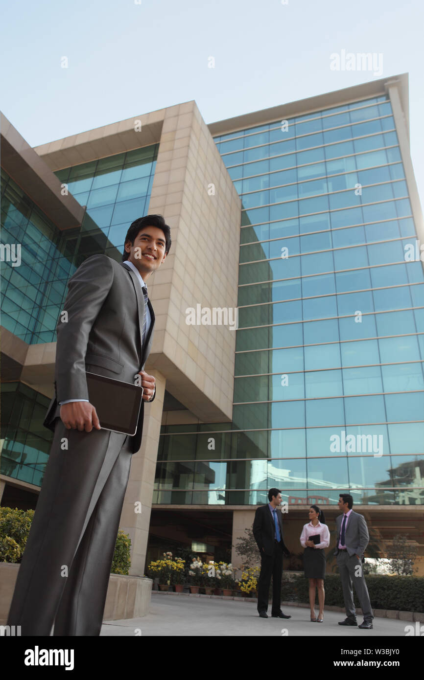 Low angle view of a businessman standing with digital tablet Stock ...