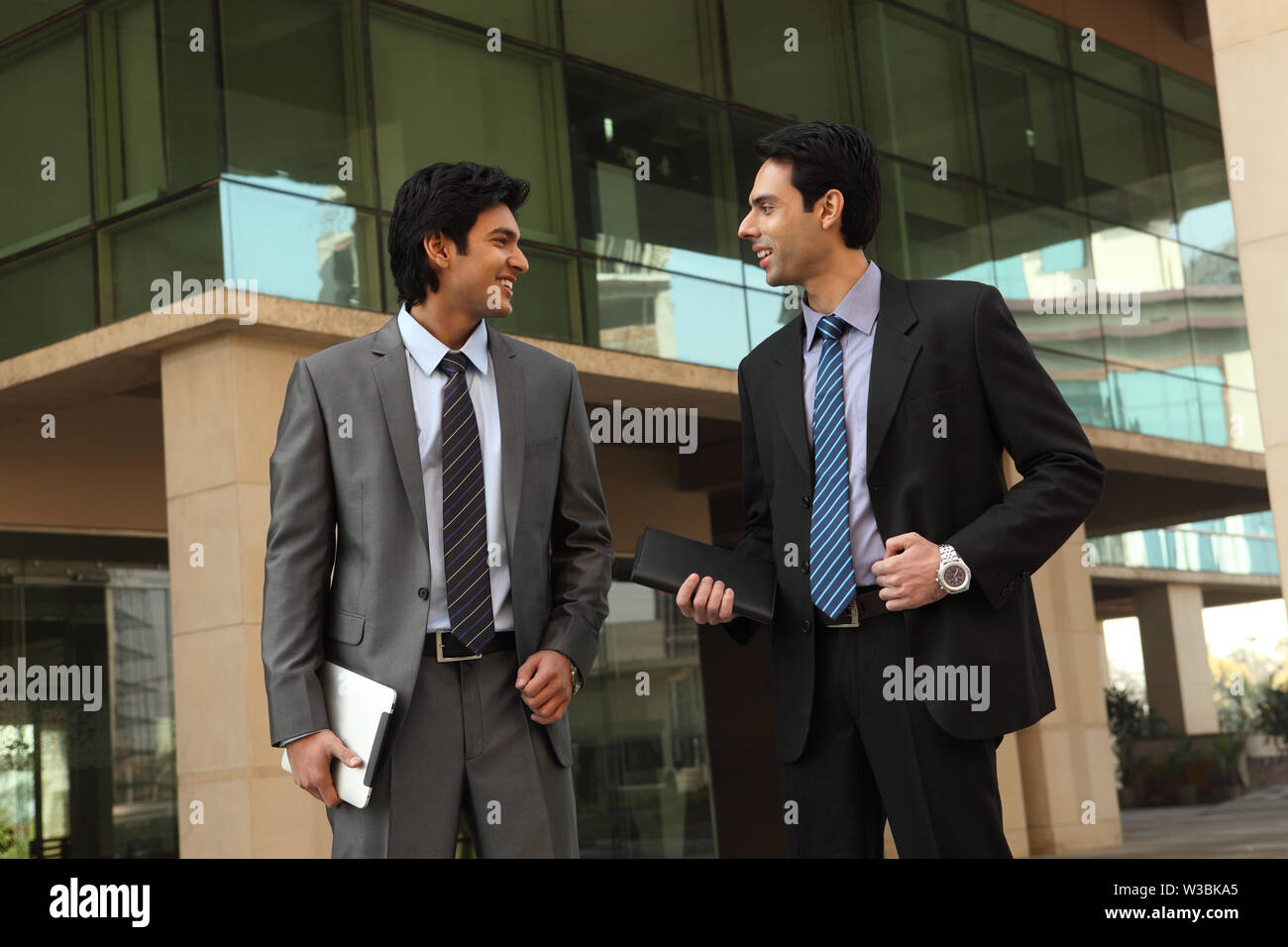 Two business executives discussing in front of office building Stock ...