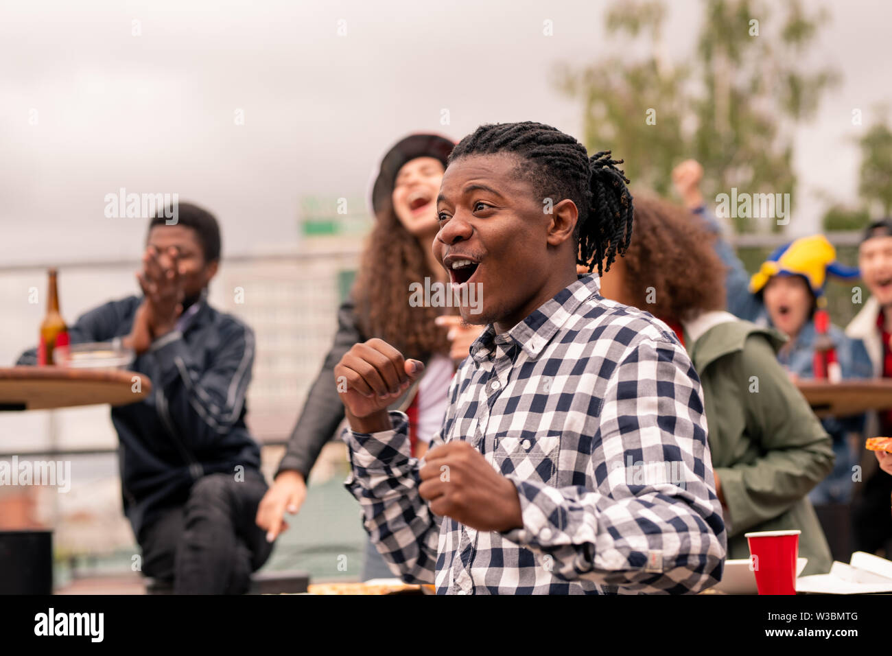 Young male football fan and his friends expressing excitement during ...
