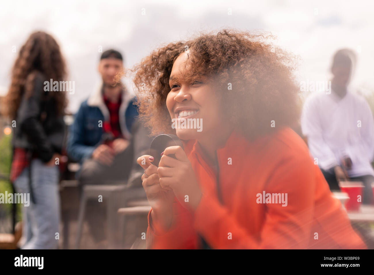 Happy mixed-race girl with puck watching hockey match broadcast Stock ...