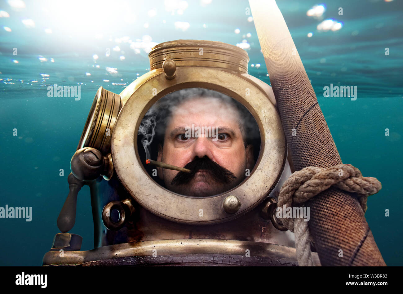 Portrait of man in old diving suit and helmet under water. Funny diver ...