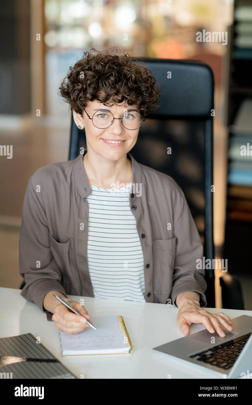 Happy brunette girl writing down her ideas on page of notebook Stock ...