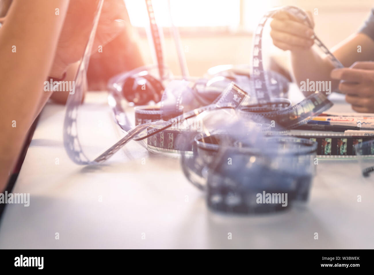 Filmmaker hands holding a film strip, cutting table Stock Photo - Alamy