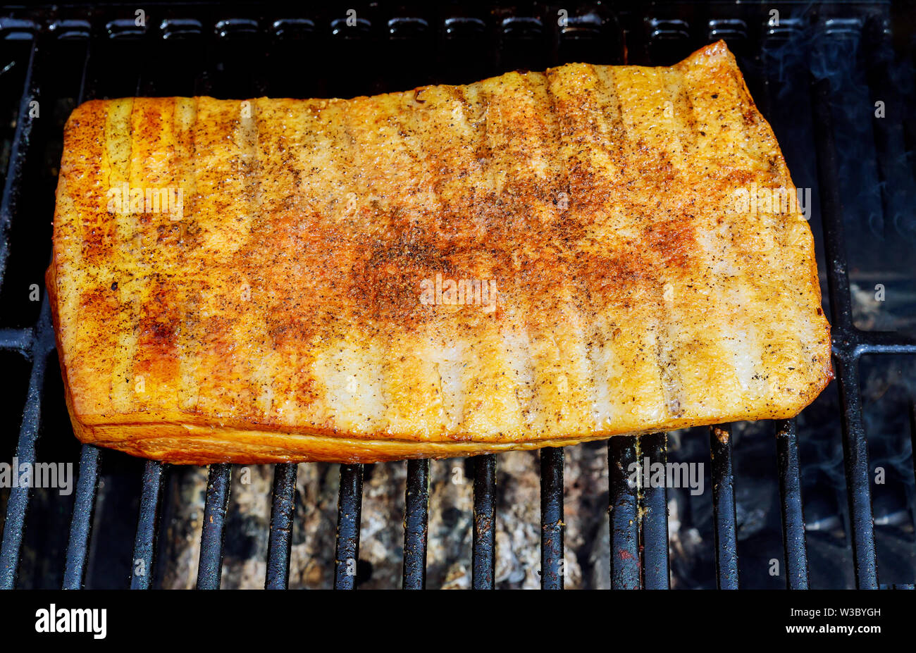 Grilled barbecue bacon on the grill with smoke in the hot smoked Stock ...
