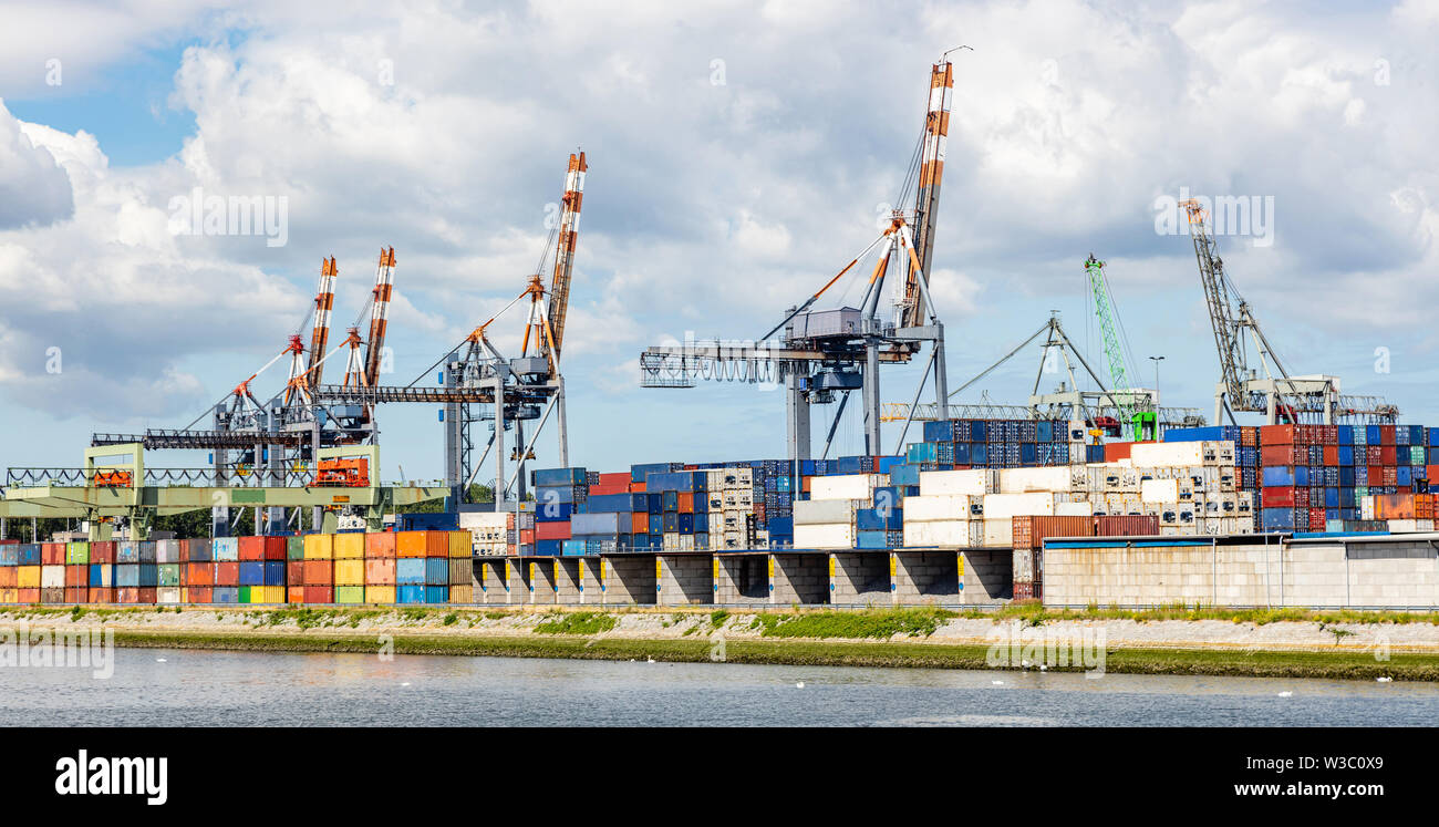 Logistics business. Stacked containers and huge bridge cranes ...