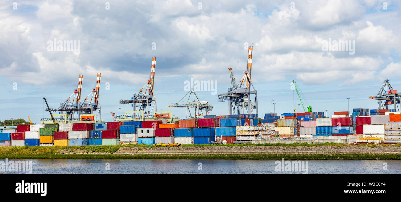 Logistics business panorama. Stacked containers and huge bridge cranes ...