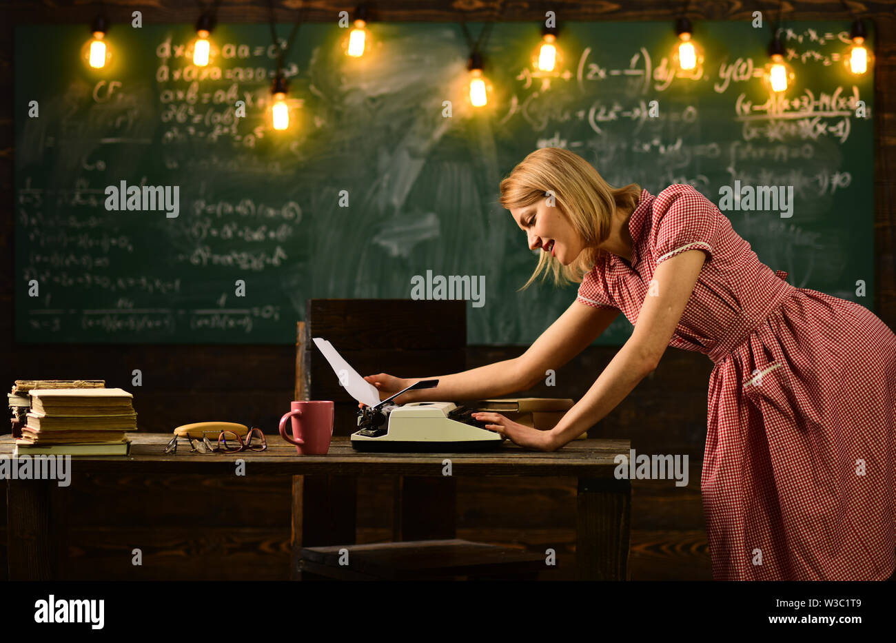 Profile of a young woman typing with a typewriter in school Stock Photo ...