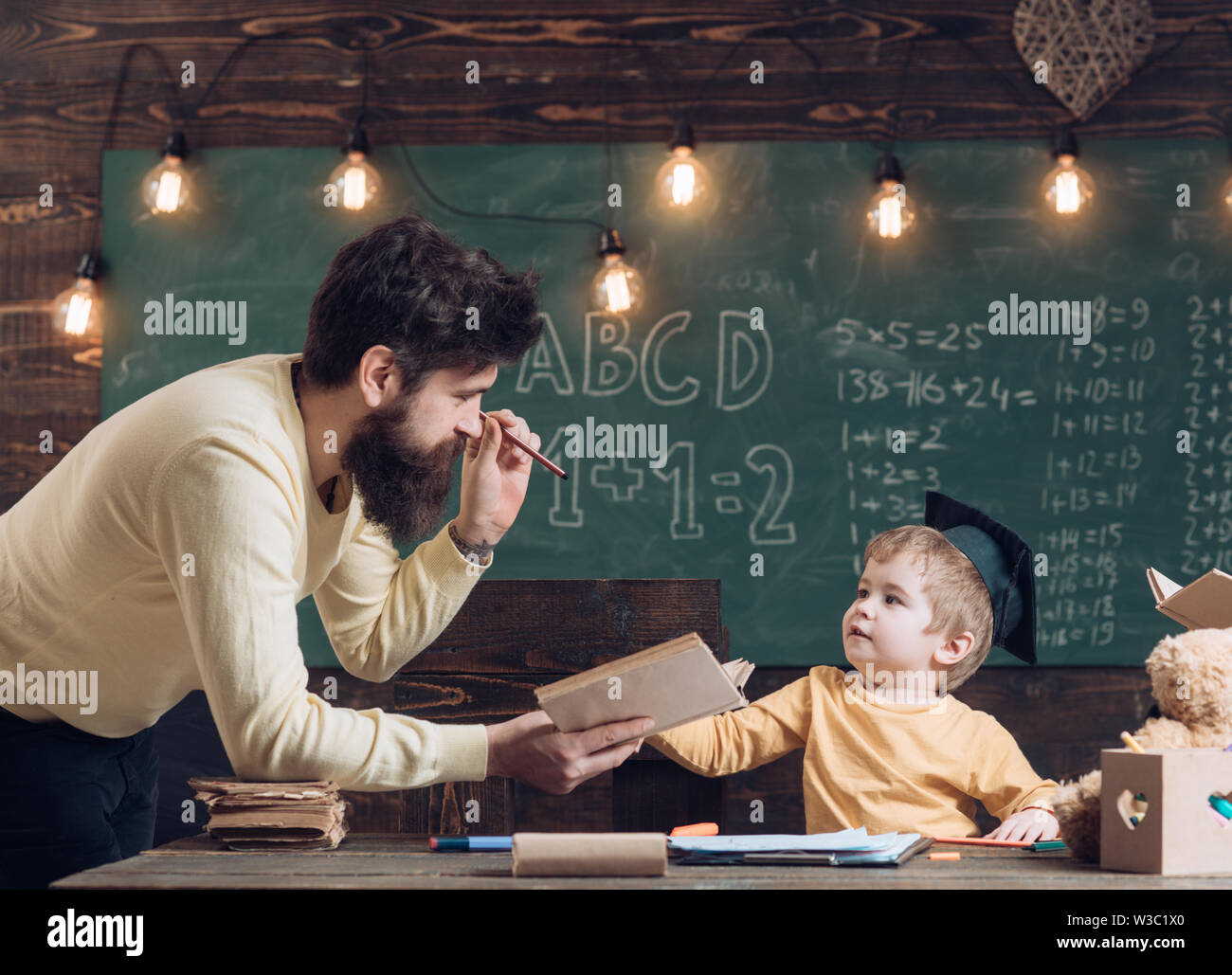 Wunderkind and genius concept. Father, teacher reading book, teaching ...