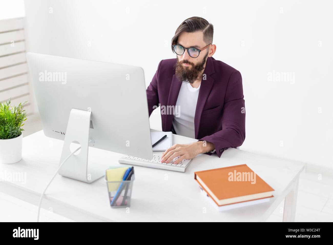 People and technology concept - Attractive man with beard working on at ...