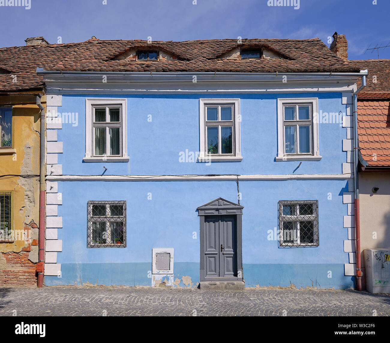 Typical Sibiu blue facade house with roof top with lucarnes appearing ...