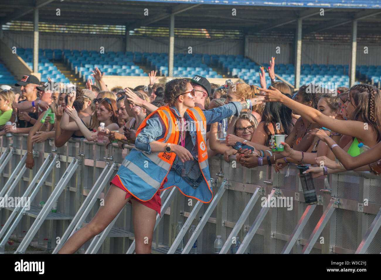 volunteer handing out water at a Festival Stock Photo - Alamy